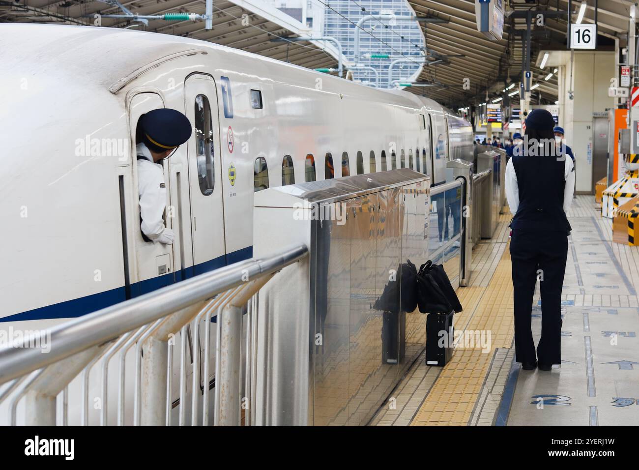 TOKYO, JAPAN - October 29, 2024: Staff wait on a platform as a ...