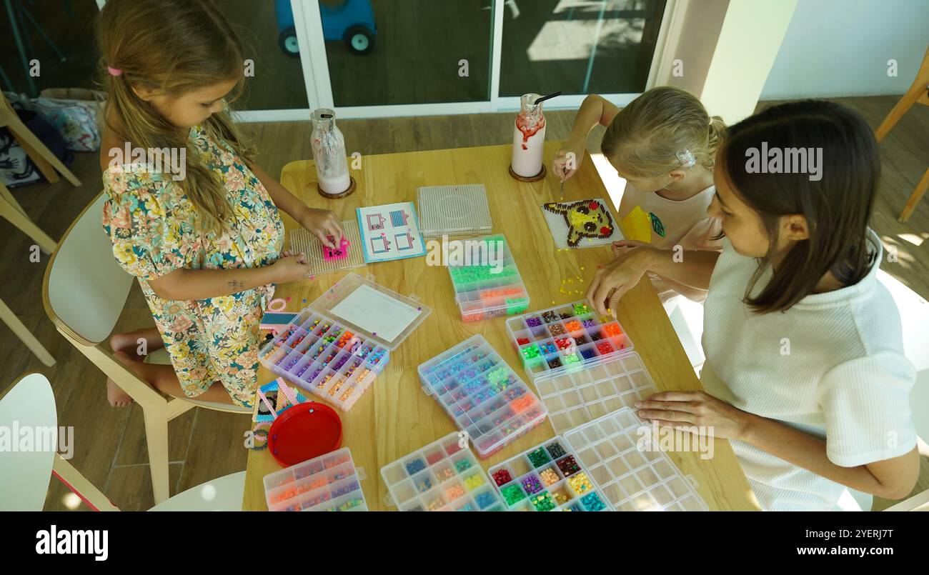 Teacher in workshop teched two girls how to assemble a thermo mosaic ...