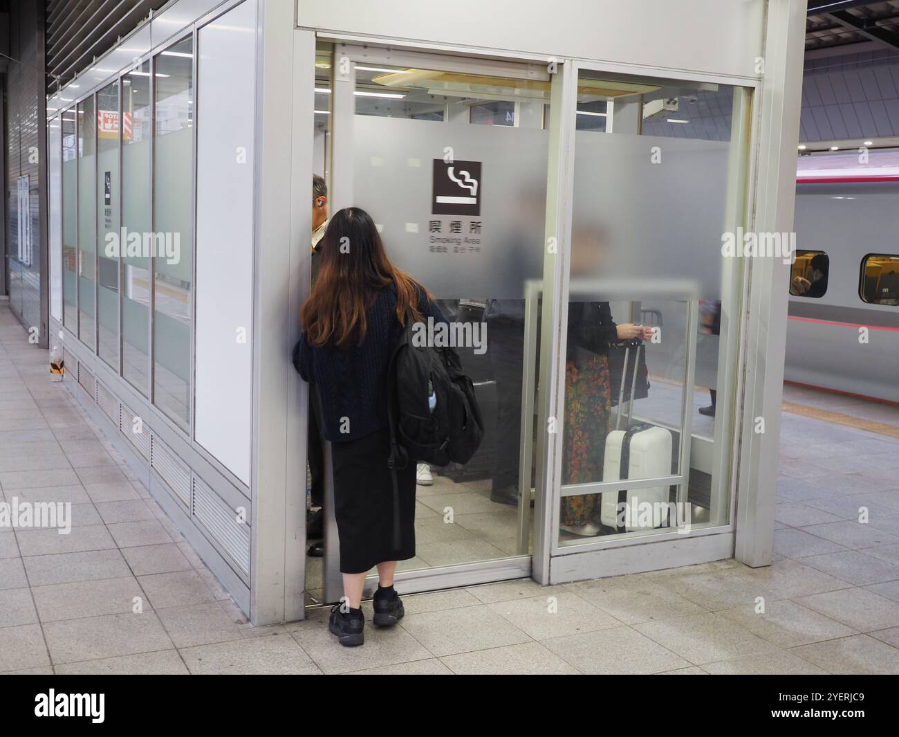 TOKYO, JAPAN - October 29, 2024: A passenger entering a smoking room on ...