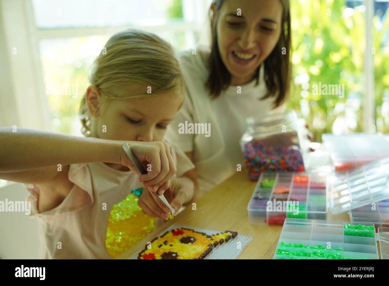 Teacher in workshop teched two girls how to assemble a thermo mosaic ...
