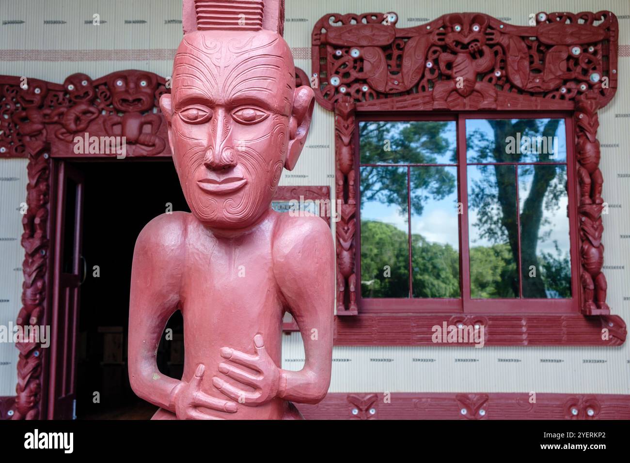 A traditional Maori wooden carving at the entrance to the meeting house ...