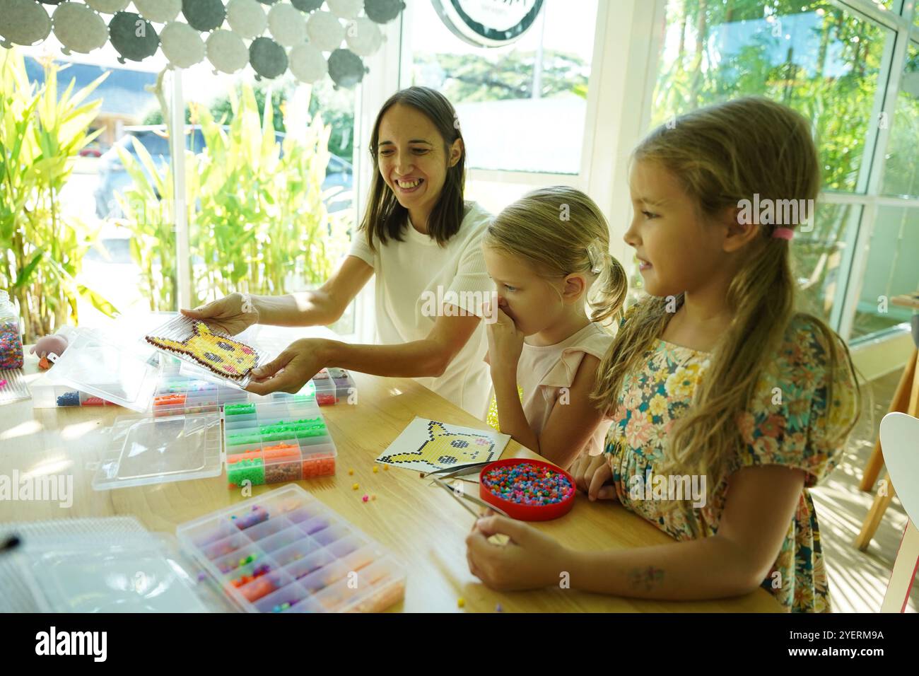 Teacher in workshop teched two girls how to assemble a thermo mosaic ...