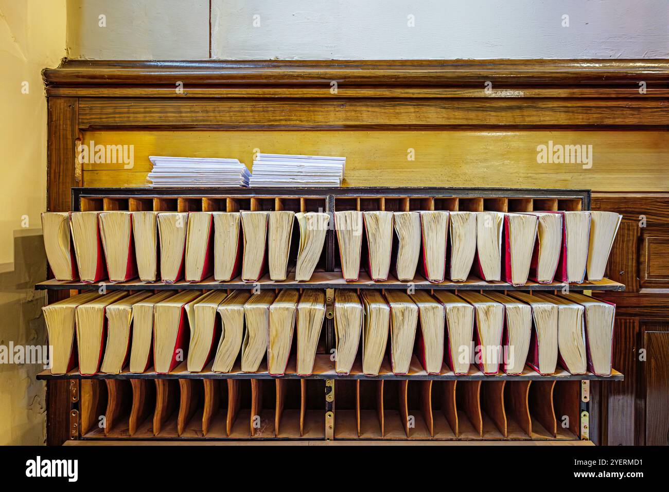 A close-up of a storage shelf filled with hymn books in a place of worship Stock Photo - Alamy