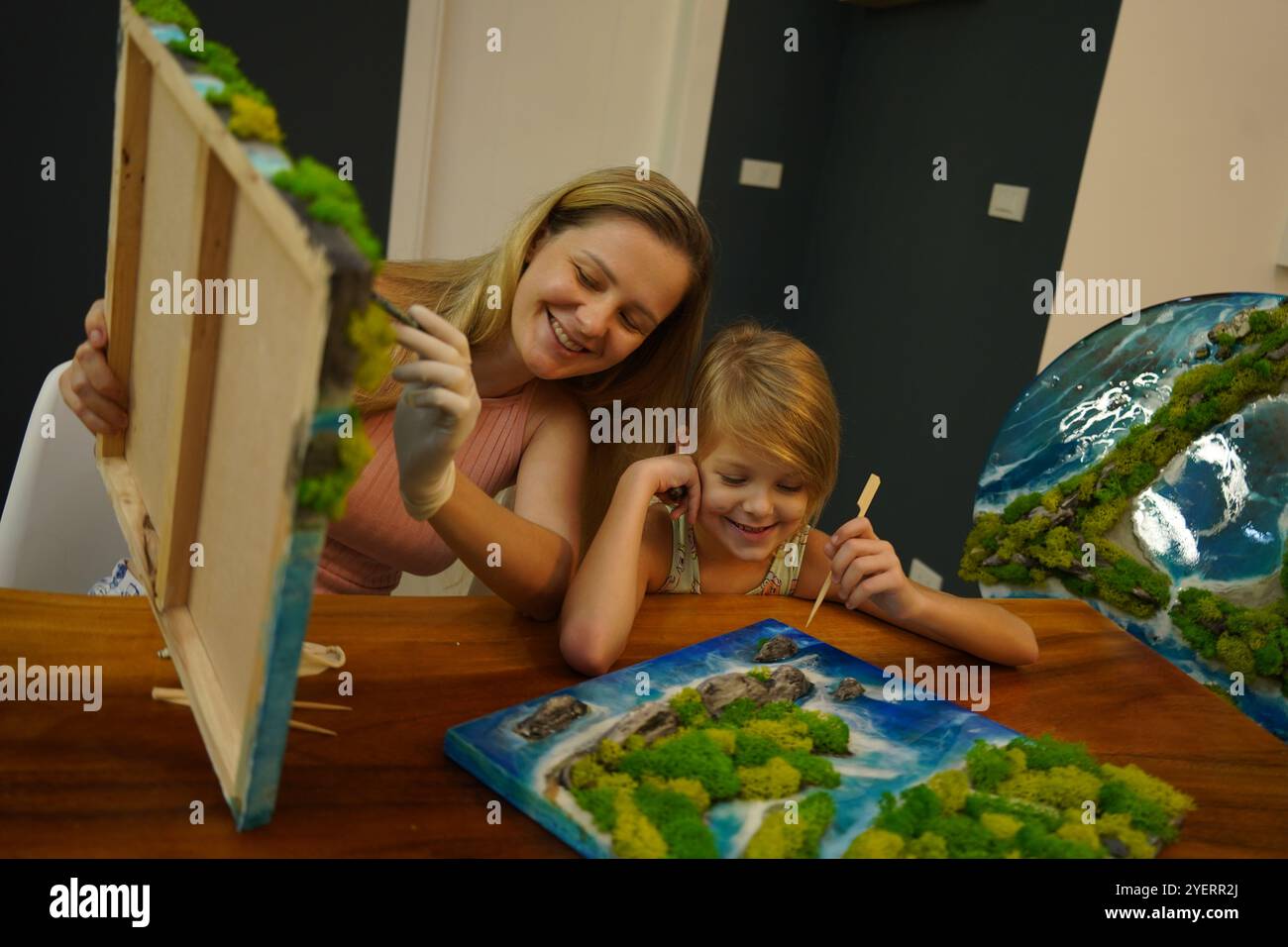 A mother and her daughter craft vibrant natural landscapes Stock Photo ...