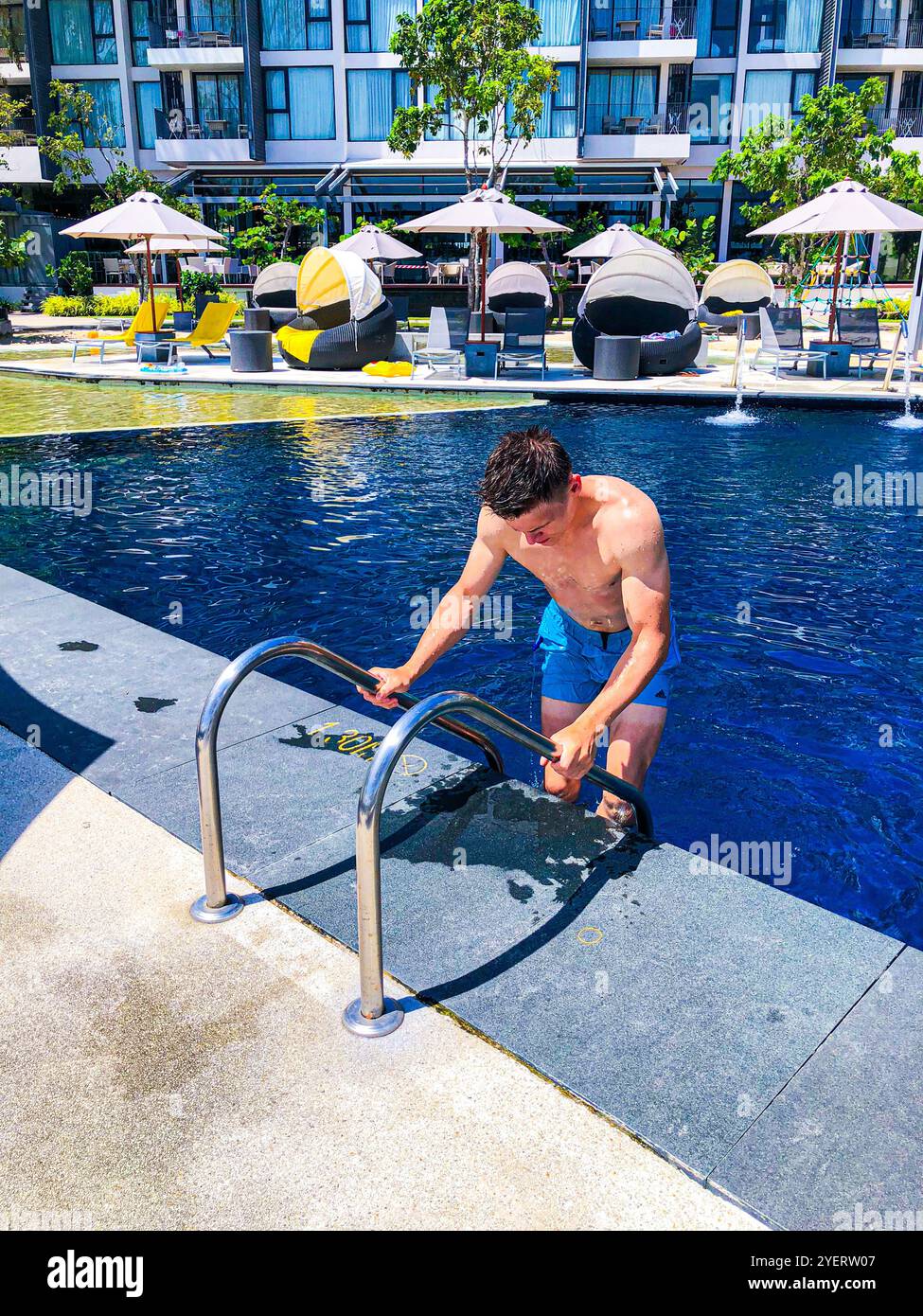 Man coming out of the pool hotel on a tropical island. seaside vacation ...