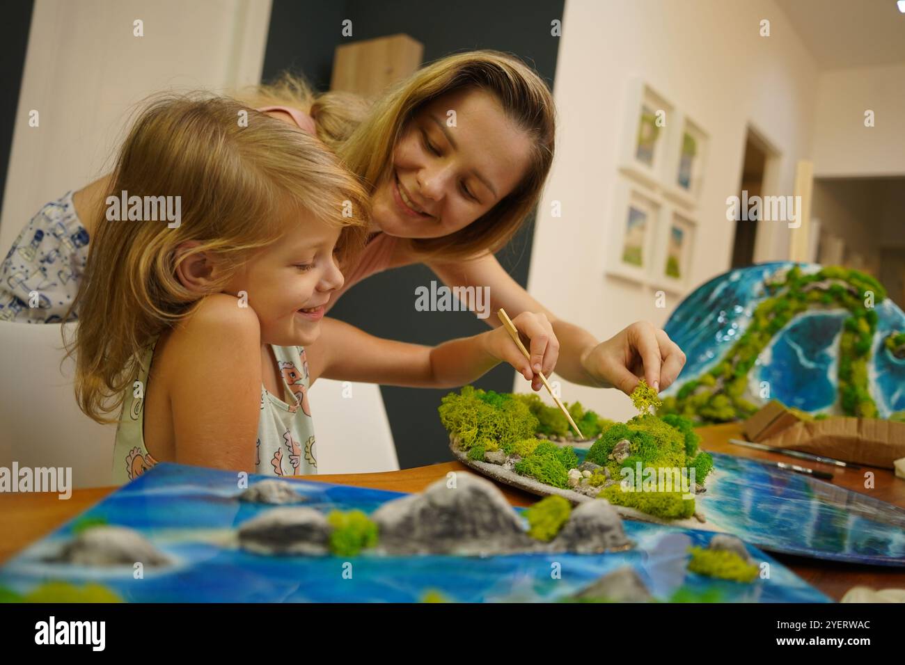A mother and her daughter craft vibrant natural landscapes Stock Photo ...