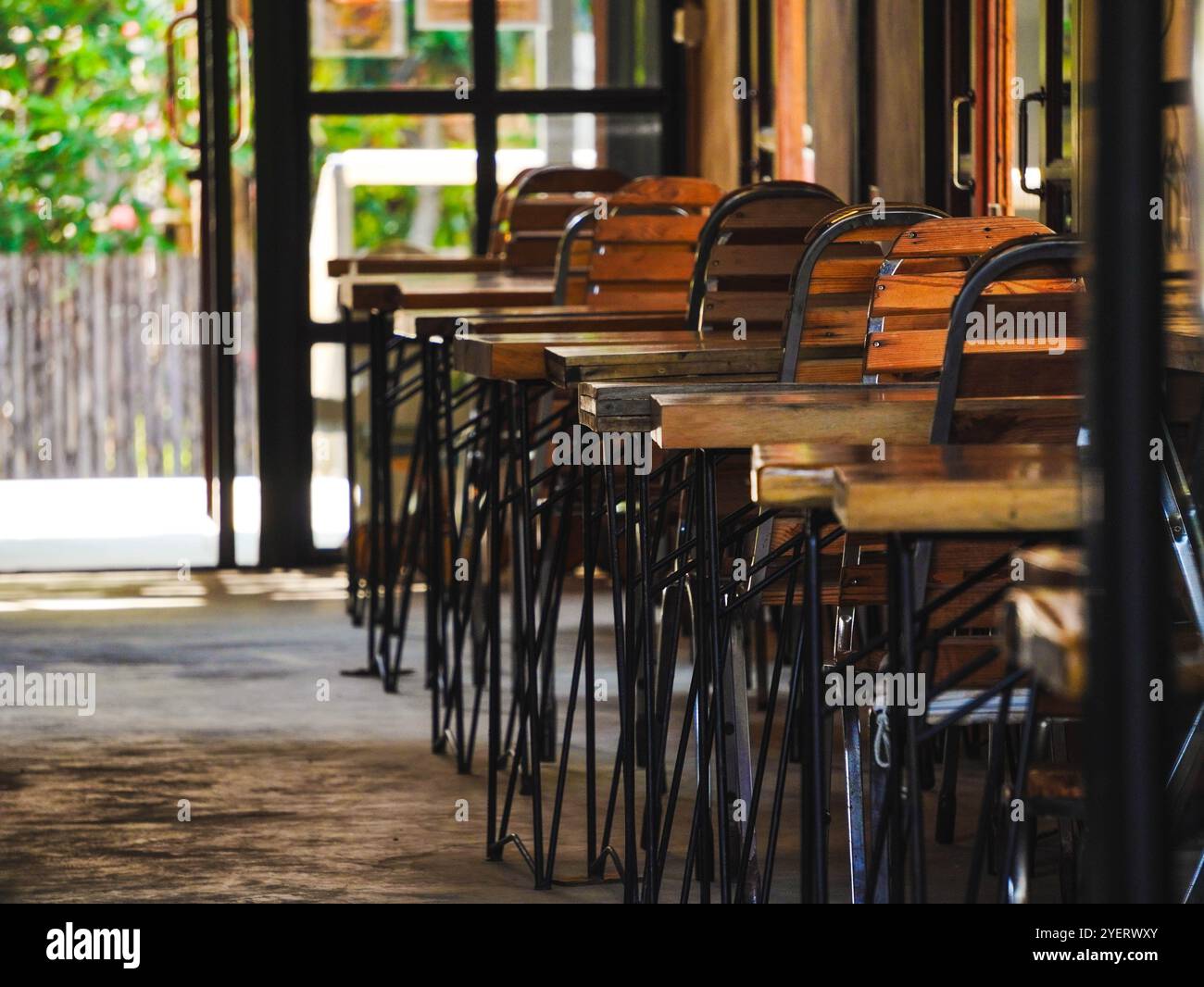 Empty cafe interior in the morning. Wooden tables and elegant wooden ...