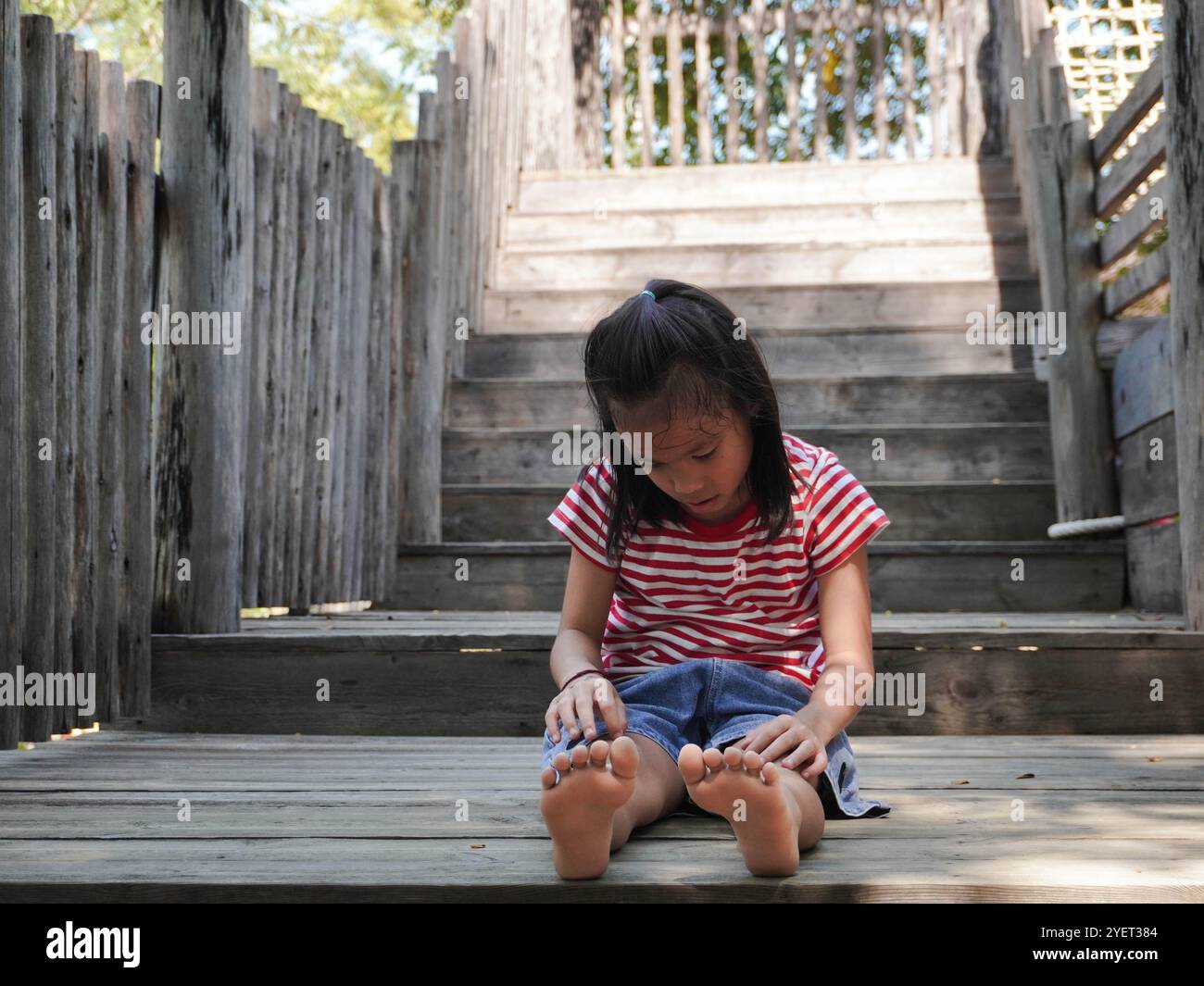 A young girl injured her knee while playing outdoors on a playground ...