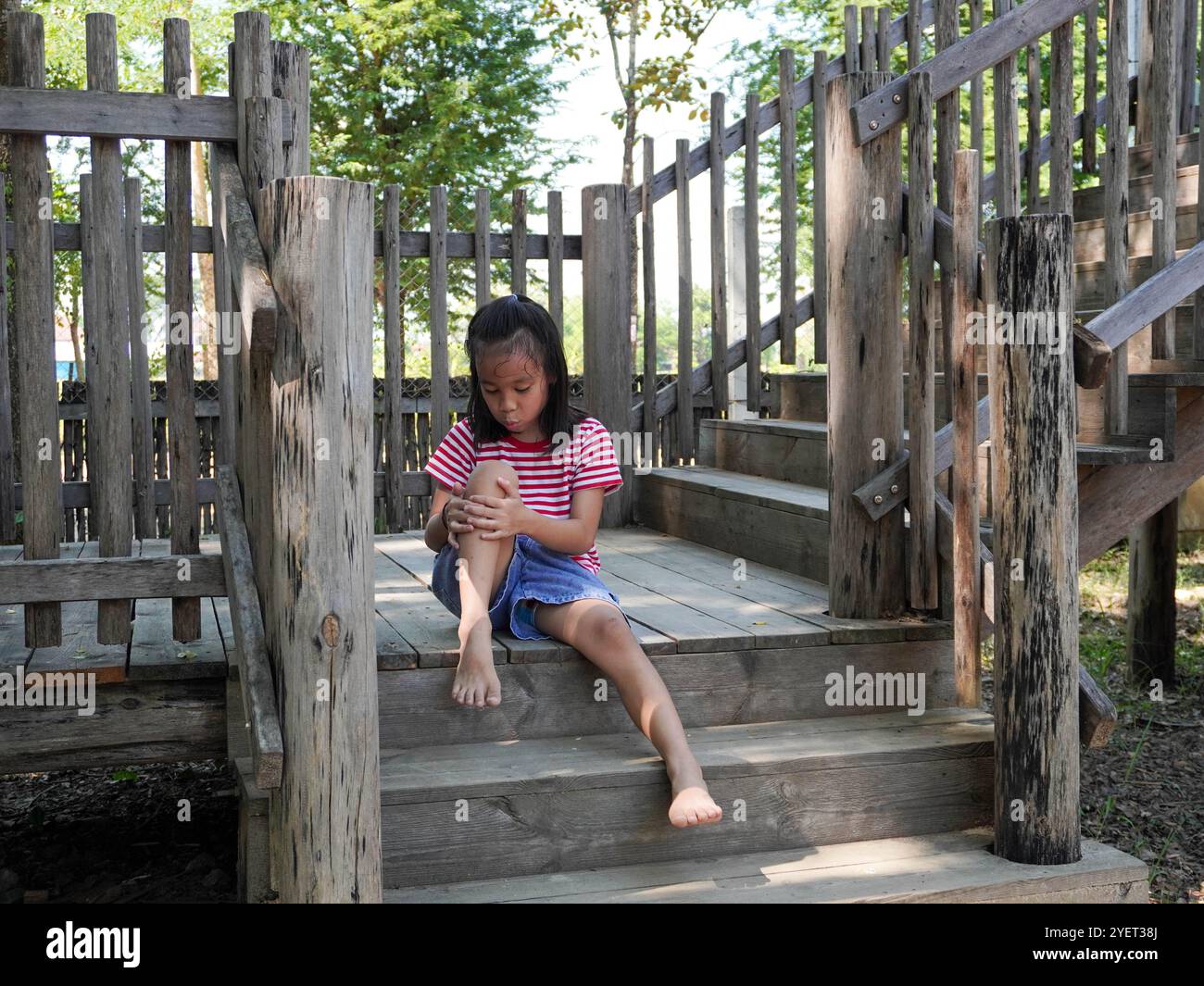 A young girl injured her knee while playing outdoors on a playground ...