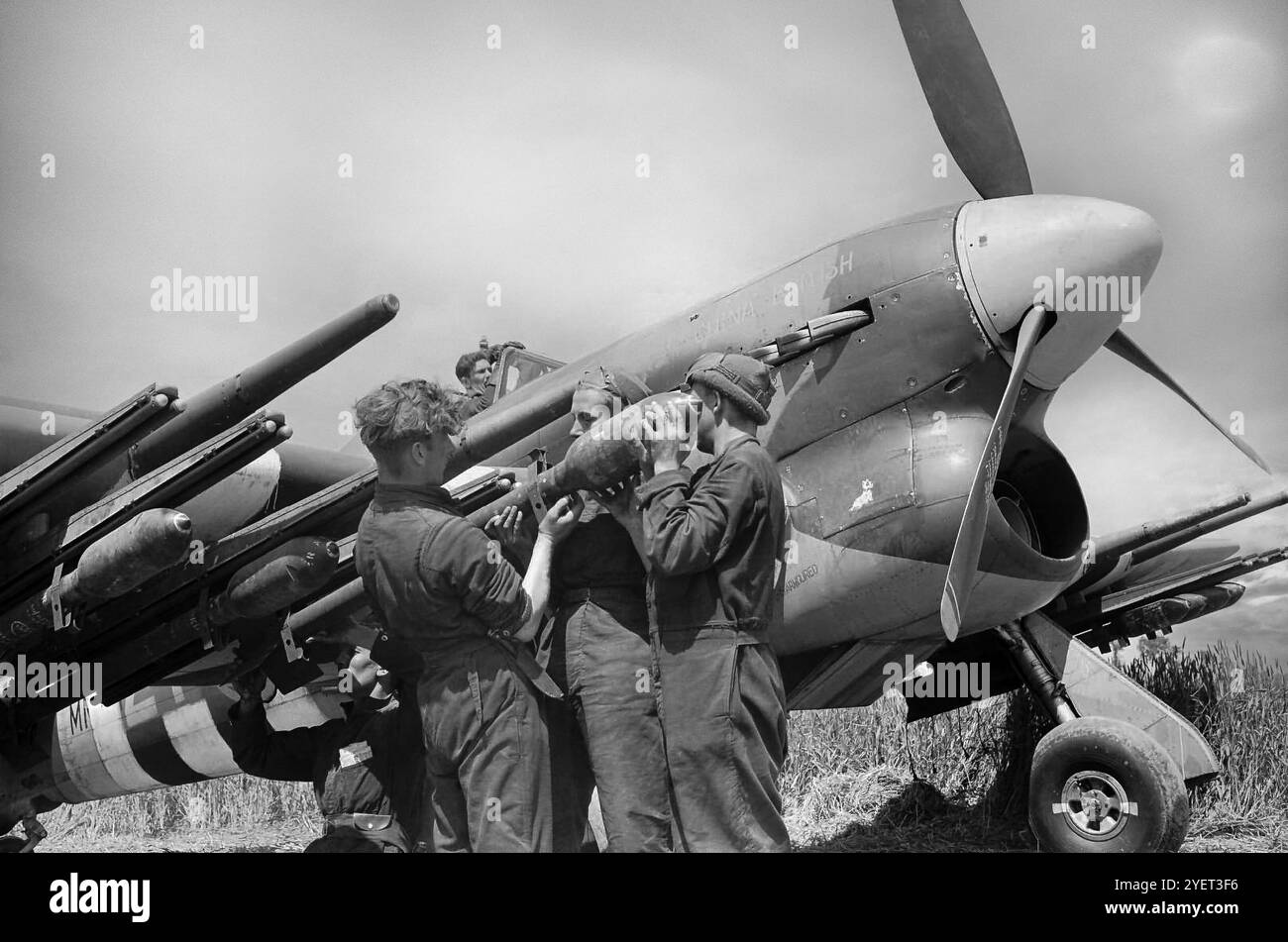 Ground crew in Bazenville, Normandy, France, arming a Hawker Typhoon, a ...