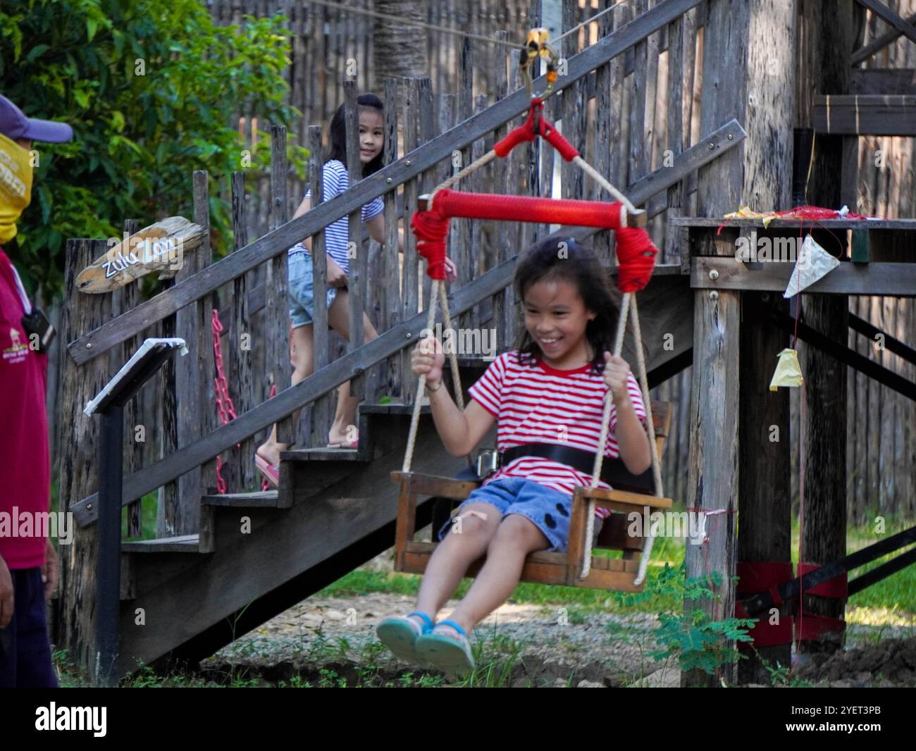 Kids play outdoors on a playground with modern slides, rope net bridges ...