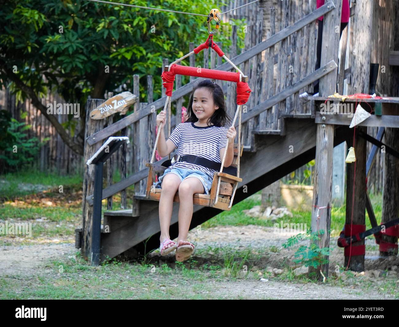 Kids play outdoors on a playground with modern slides, rope net bridges ...