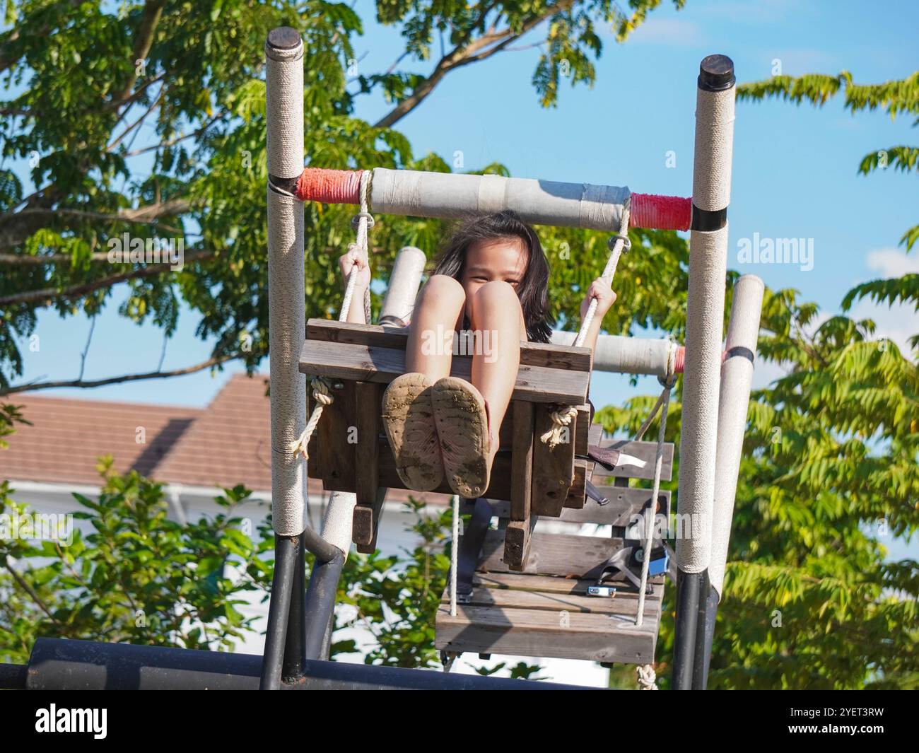 Kids play outdoors on a playground with modern slides, rope net bridges ...