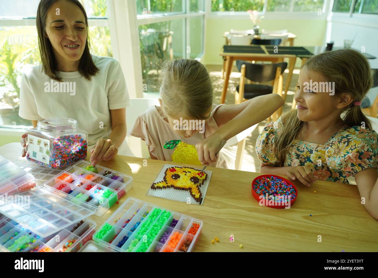 Teacher in workshop teched two girls how to assemble a thermo mosaic ...
