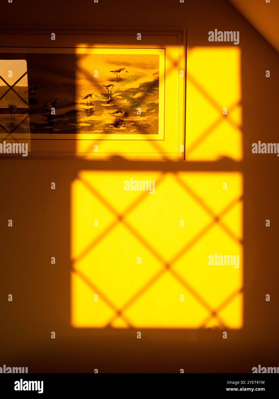 Glowing dawn sunlight at sunrise streaming through a house window ...