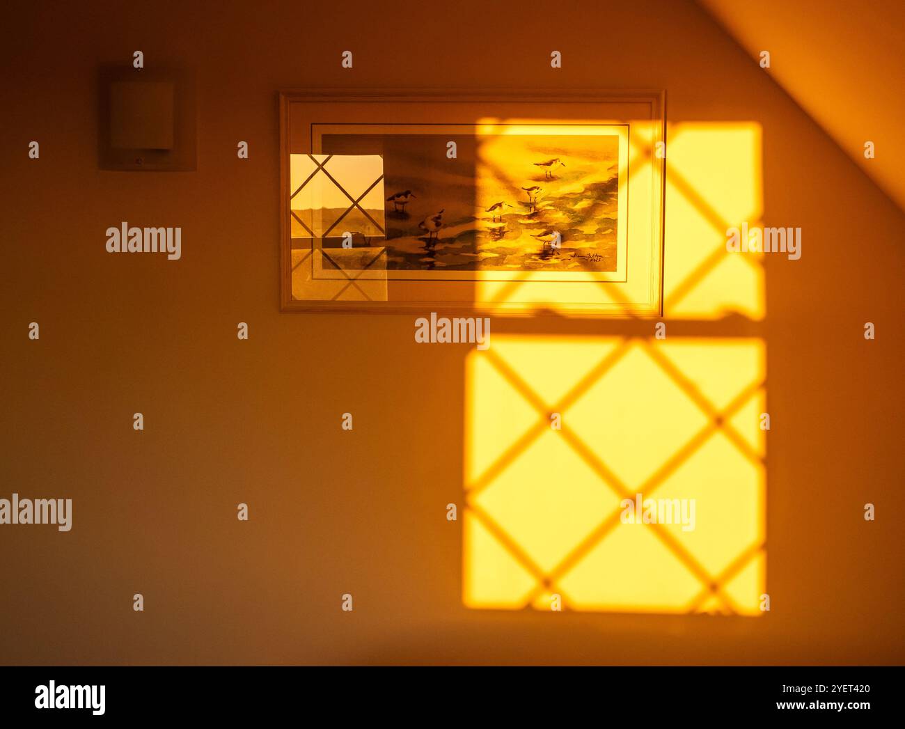 Glowing dawn sunlight at sunrise streaming through a house window ...