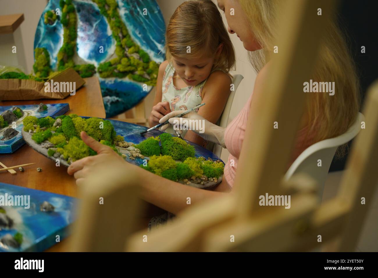 A mother and her daughter craft vibrant natural landscapes Stock Photo ...
