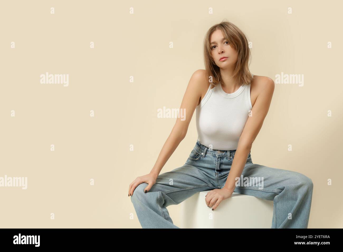 Serie of studio photos of woman in classic basic outfit - blue jeans and white tank top Stock ...