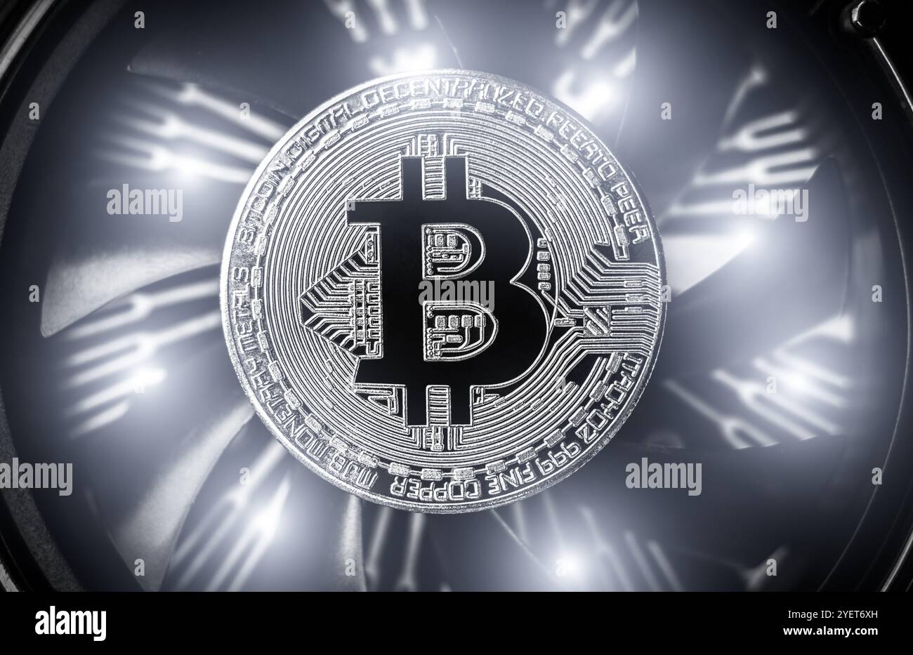 Bitcoin on cooling computer fan background. Silver bitcoin coin on ...