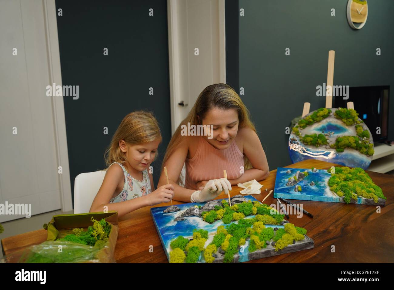 A mother and her daughter craft vibrant natural landscapes Stock Photo ...