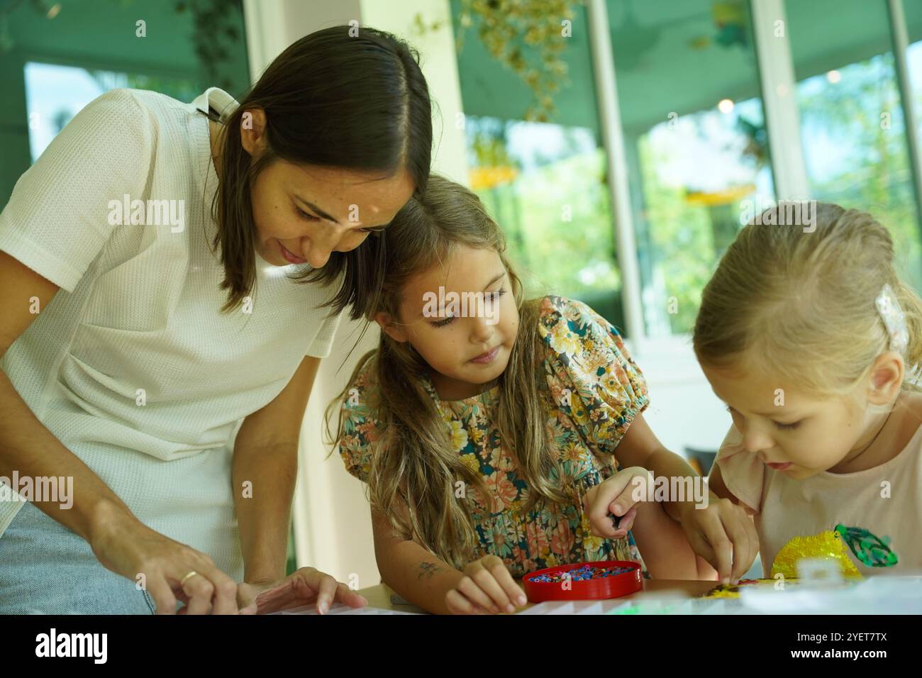 Teacher in workshop teched two girls how to assemble a thermo mosaic ...