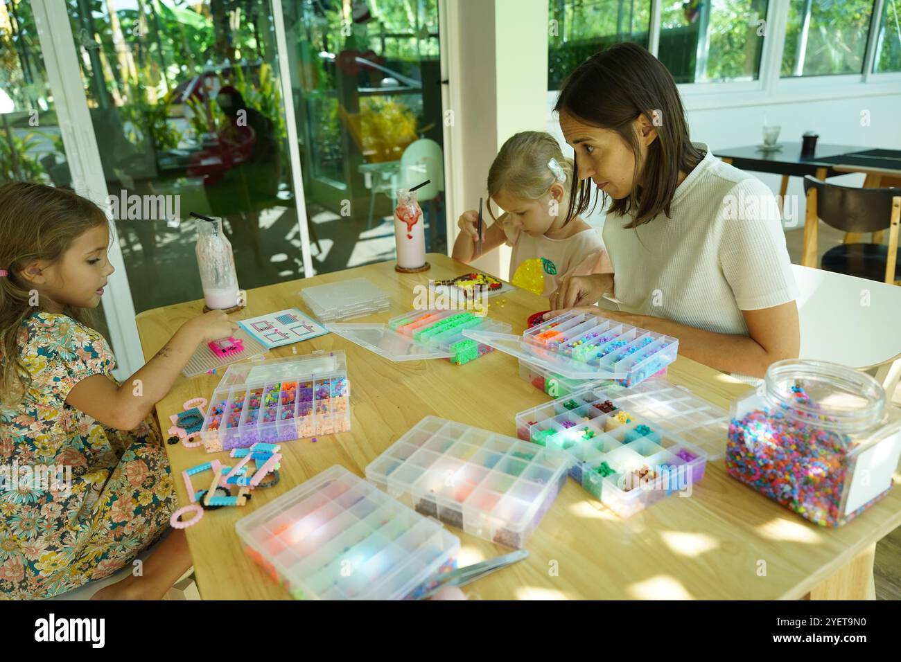 Teacher in workshop teched two girls how to assemble a thermo mosaic ...
