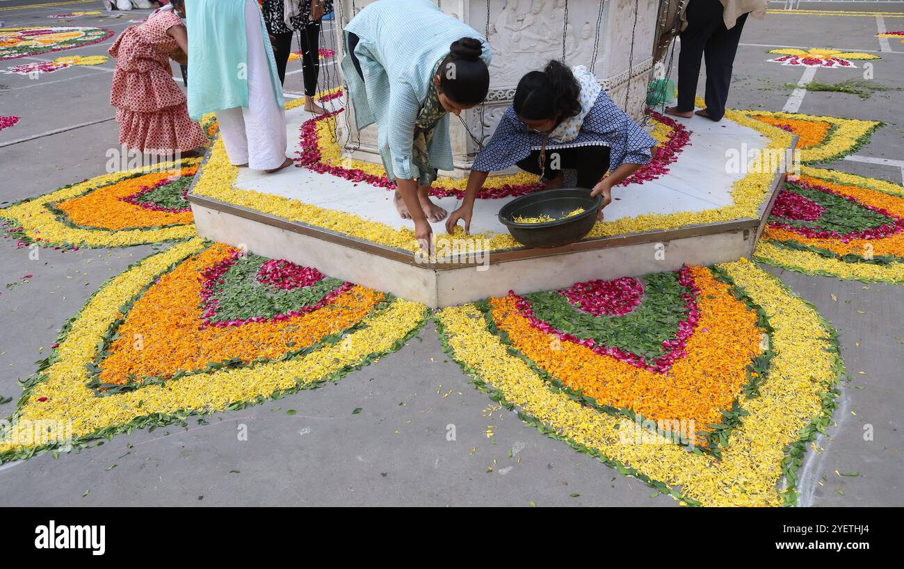 Women creating rangoli patterns from the petals of flowers, to ...