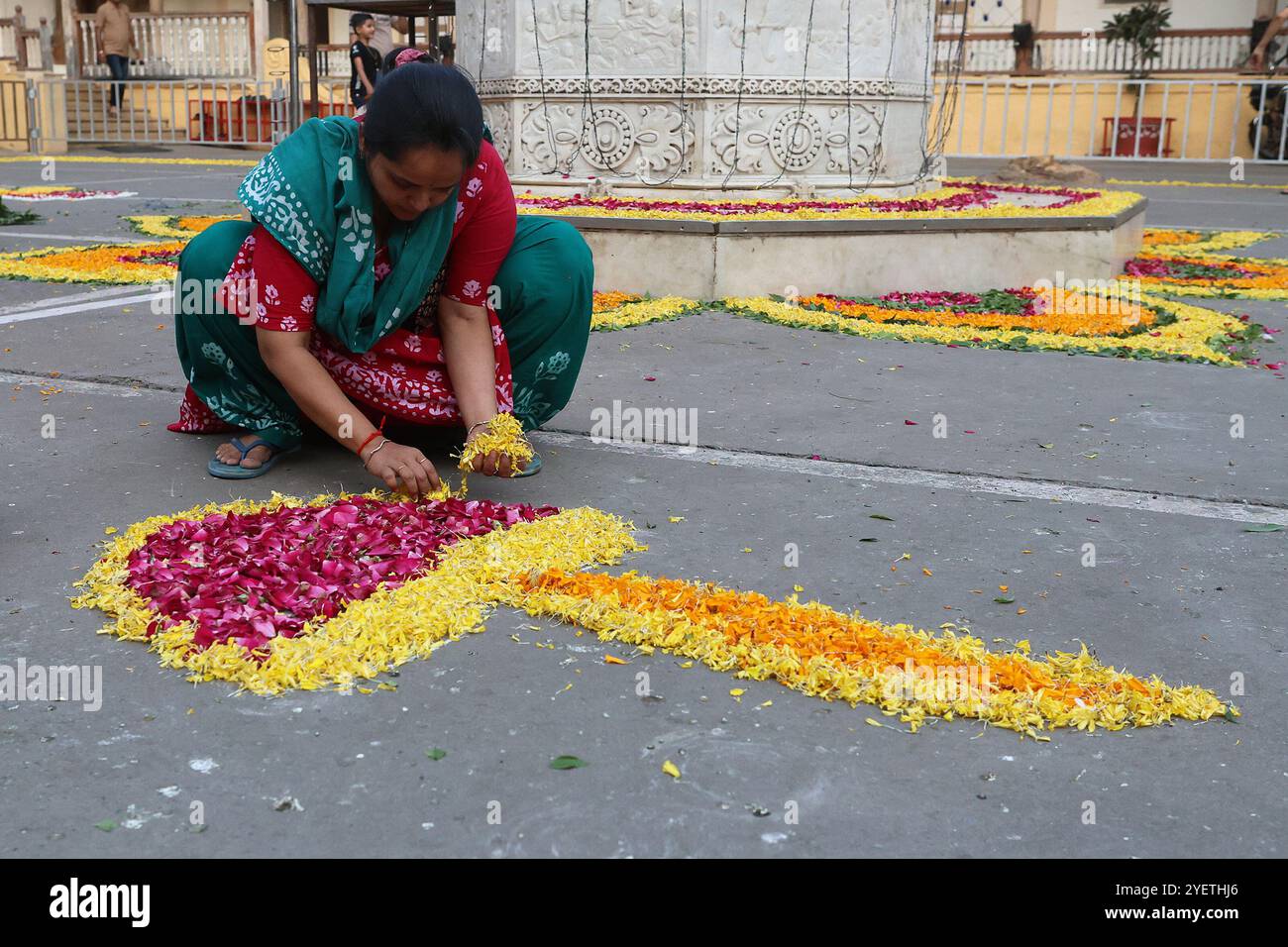 Women creating rangoli patterns from the petals of flowers, to ...