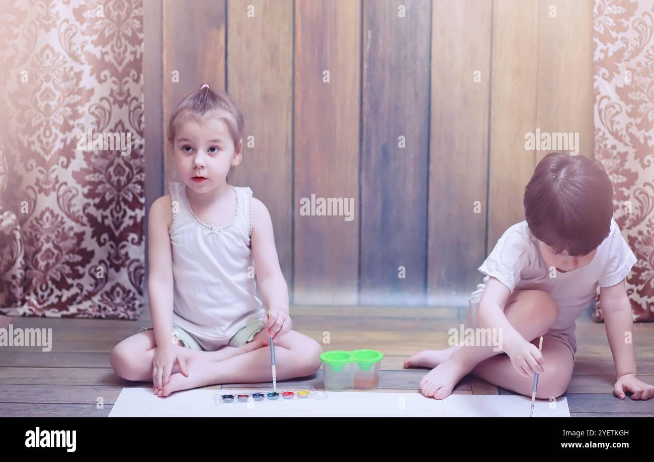 Little children paint on a large sheet of paper on the floor Stock ...