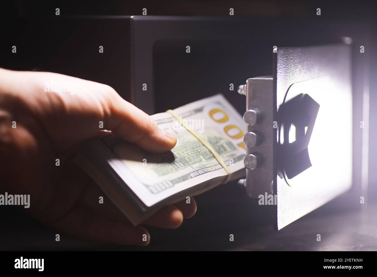 Steel safe with money. Hand putting password in the safety money box in ...