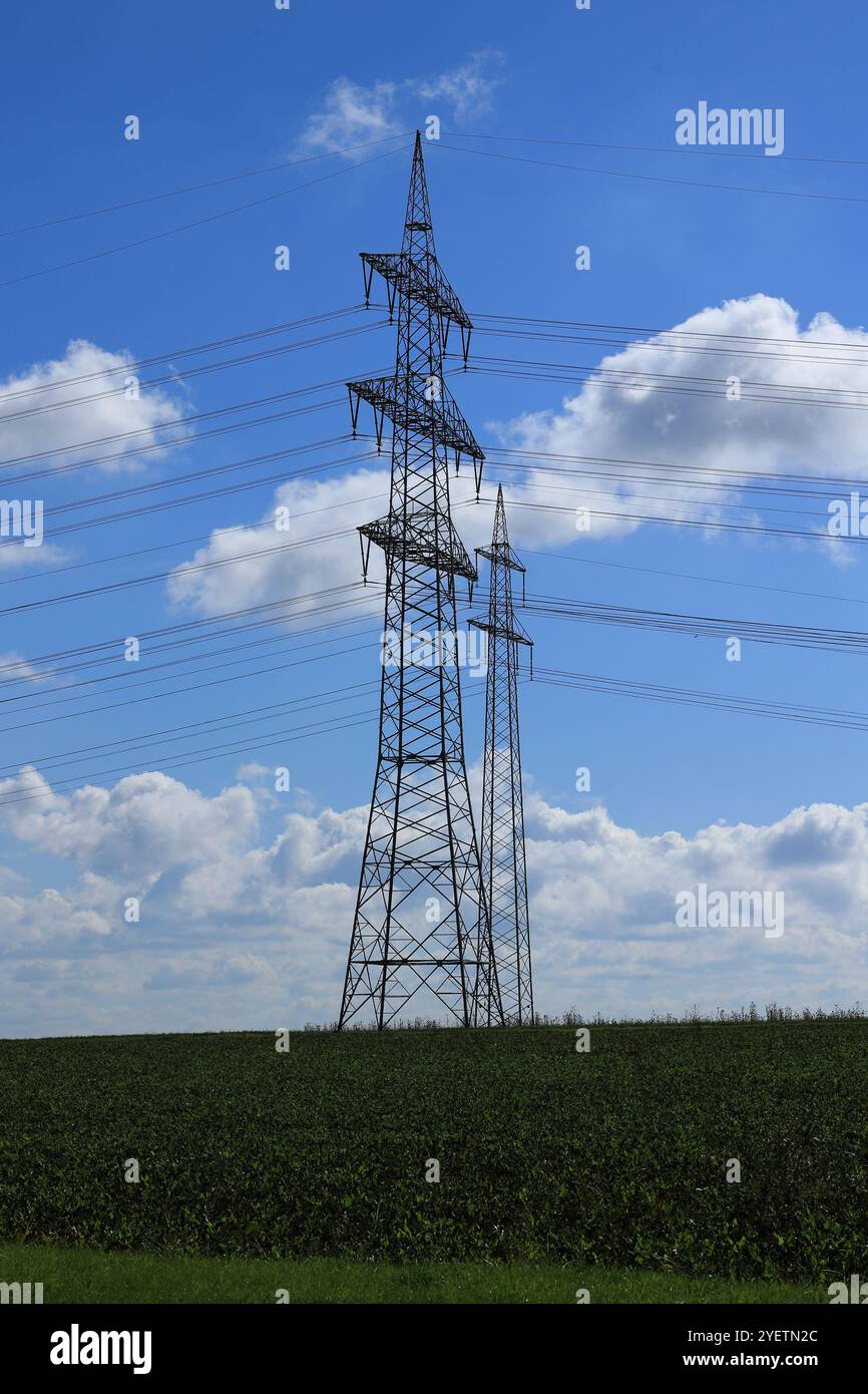 High-voltage pylons stand one behind the other, offset laterally Stock ...