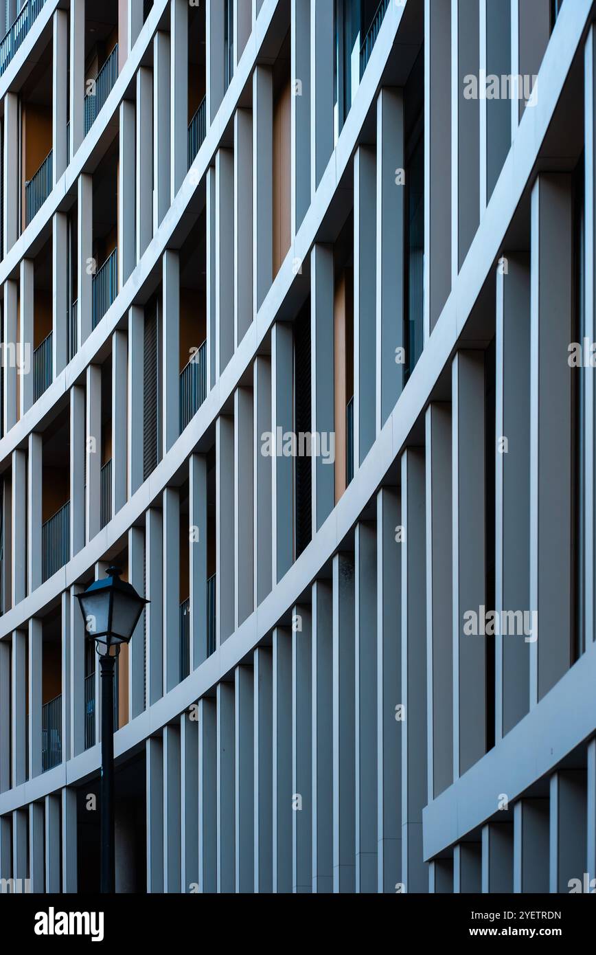 A modern curved building facade featuring rhythmic lines and windows in ...