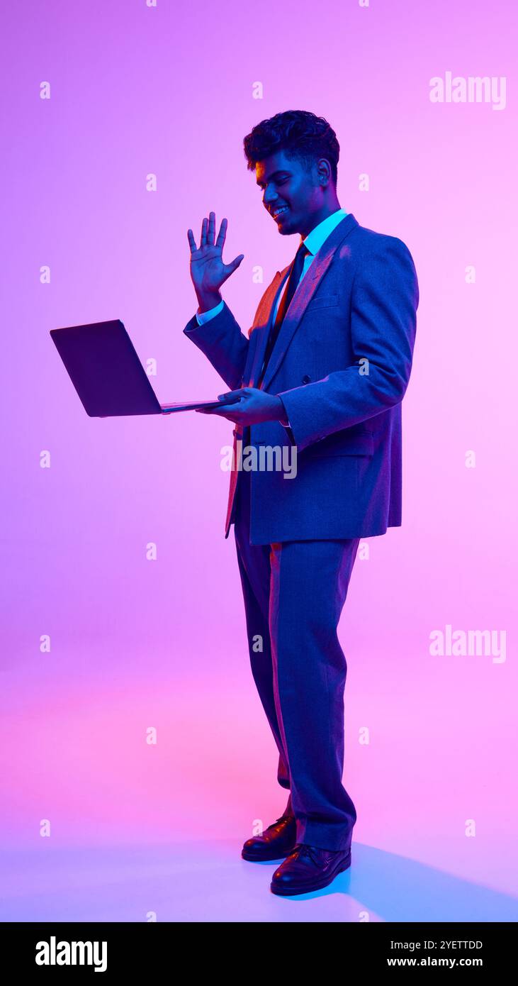 Portrait of young smiling Indian man in formal wear holding laptop and ...