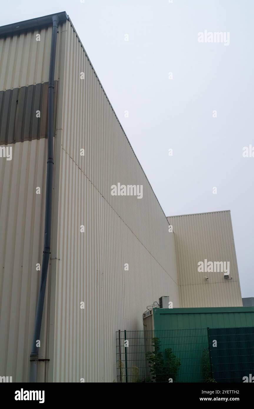 Metal cladding on an industrial building with downspout and security ...