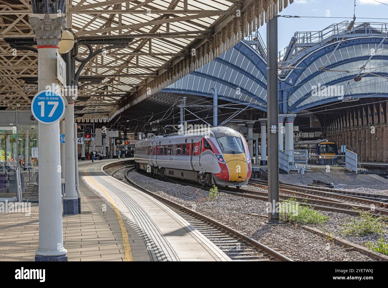 A train enters a railway station with historic 19th Century iron and ...
