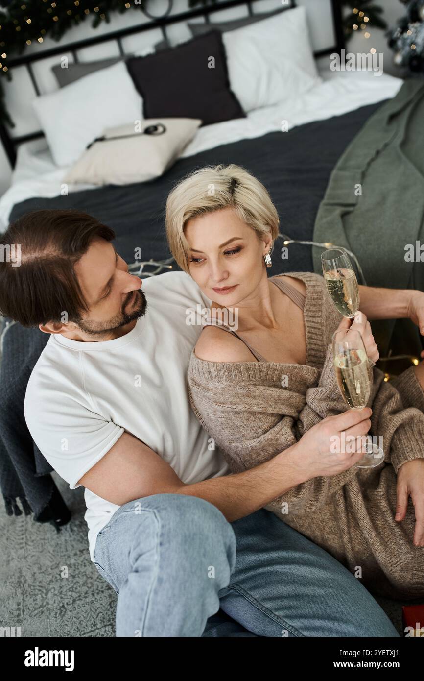 A couple enjoys a heartfelt moment together, celebrating with glasses ...