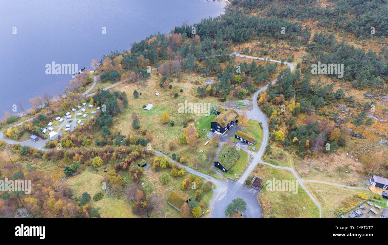 Aerial view of a lakeside campsite surrounded by forested hills. The ...