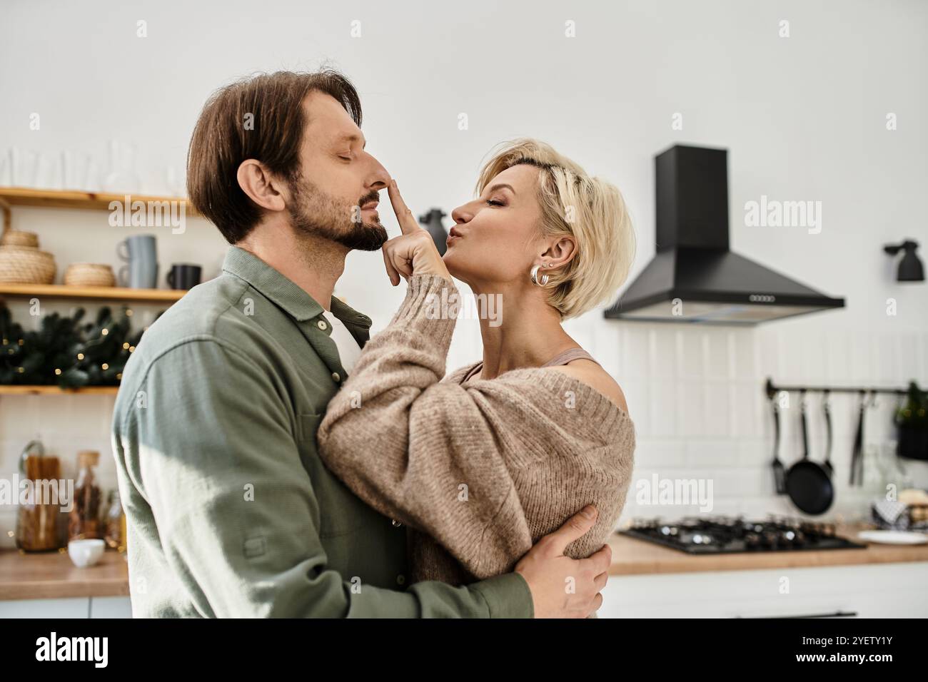 A couple smiles and playfully engages in a sweet moment at home in ...