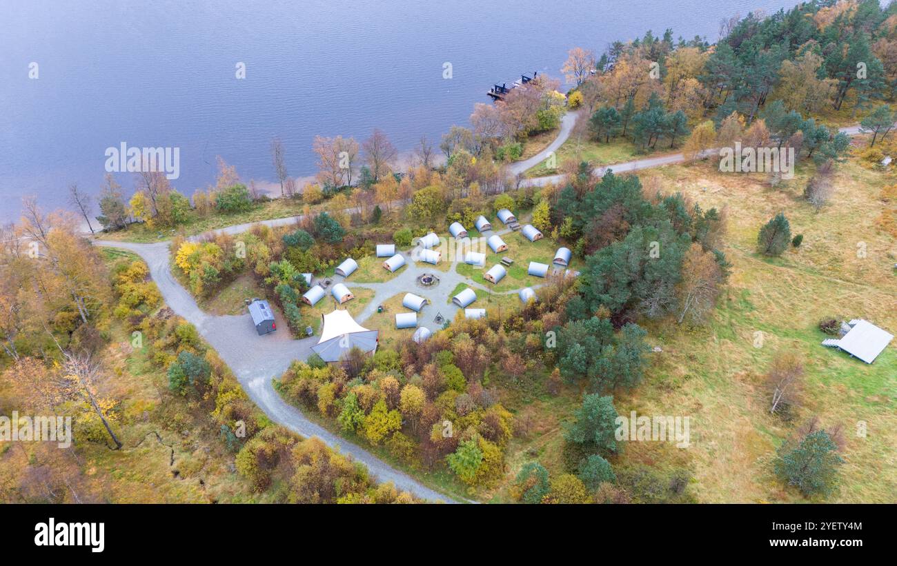 Aerial view of a lakeside campsite with multiple tents arranged in a ...