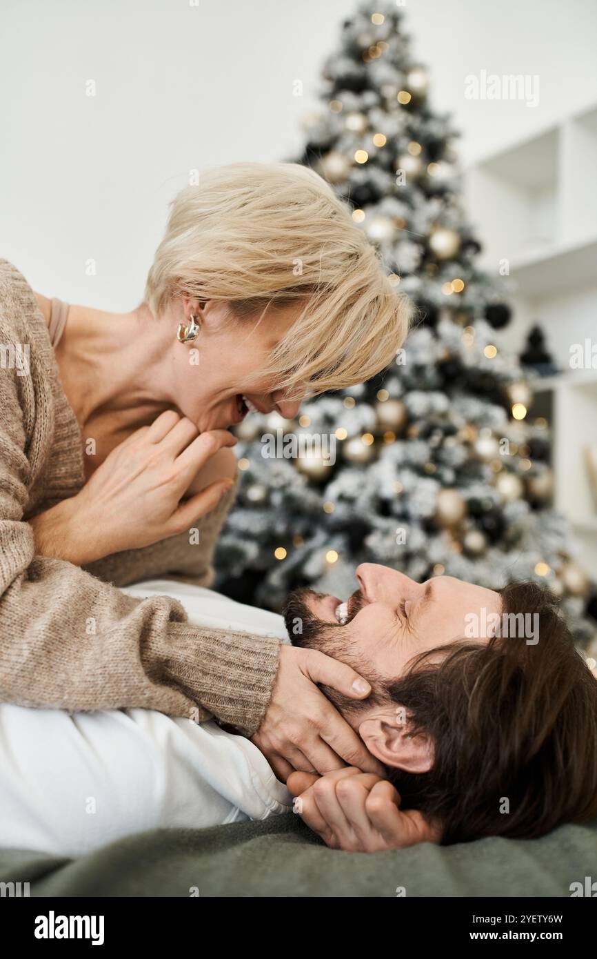 A loving couple enjoys a playful moment at home, embracing and laughing ...