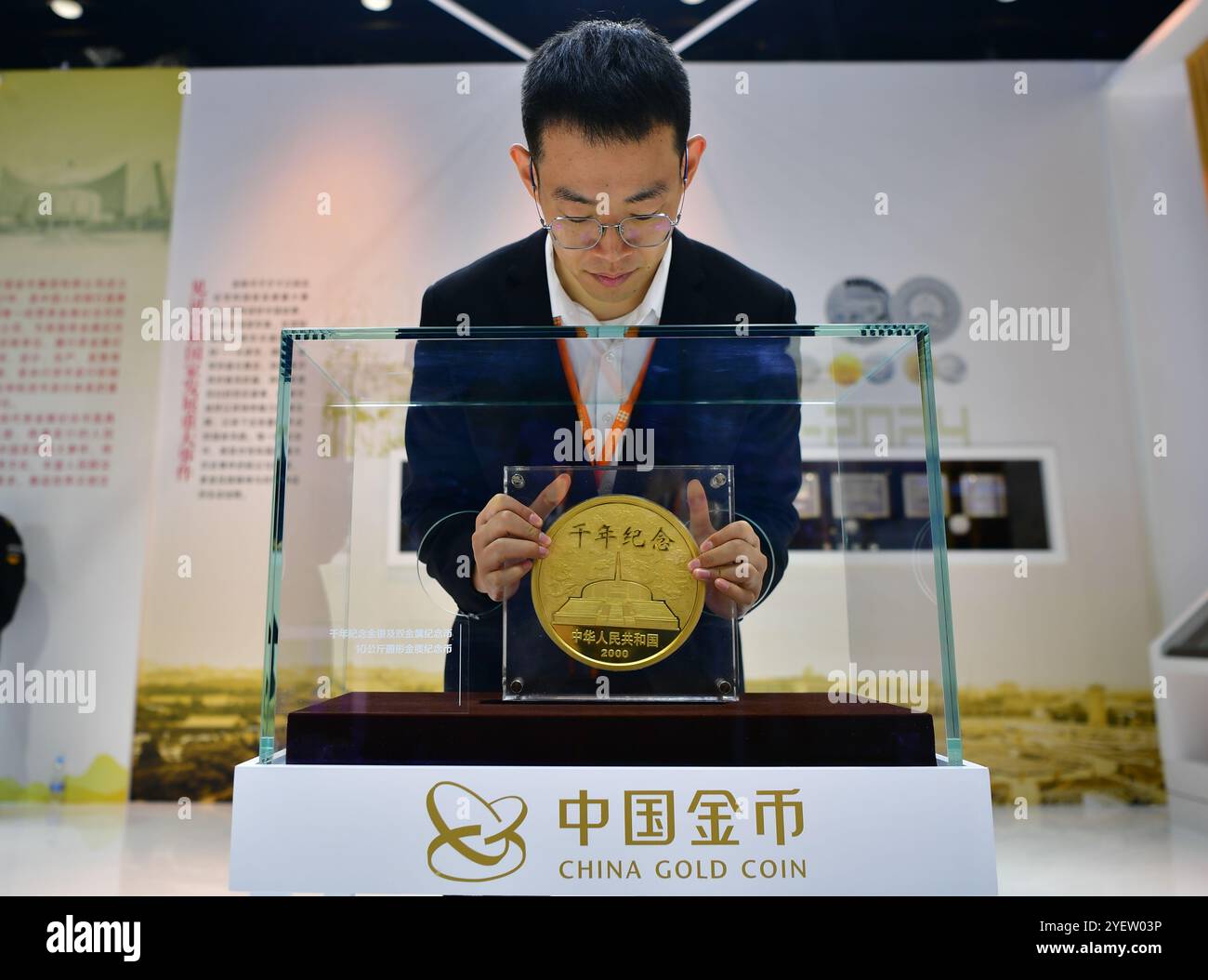 Beijing, China. 1st Nov, 2024. An exhibitor shows a commemorative gold ...