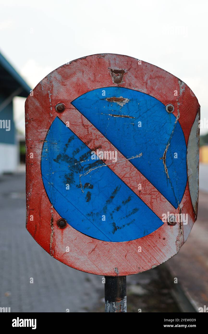A close-up of a faded and rusty No Parking sign, showcasing textures ...