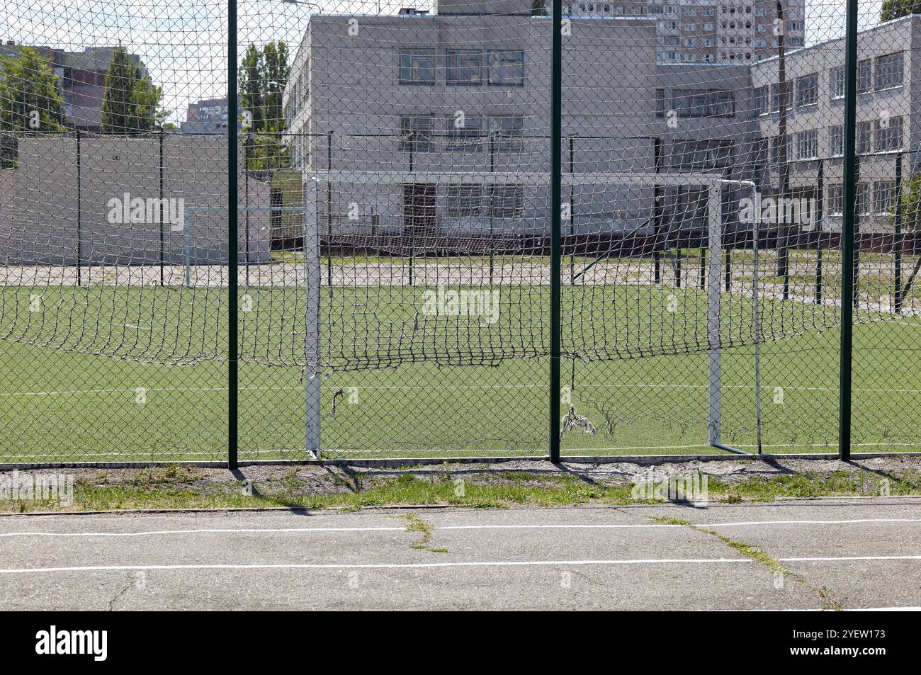 Lawn field for playing football behind the green fence mesh at school ...