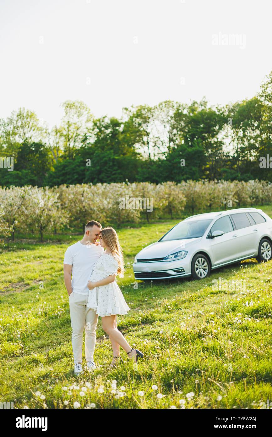 Romantic pregnant couple in love hugging in blooming apple spring ...