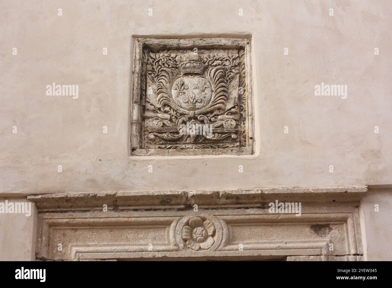 A coat of arms carved into the wall above the front door of a house in ...