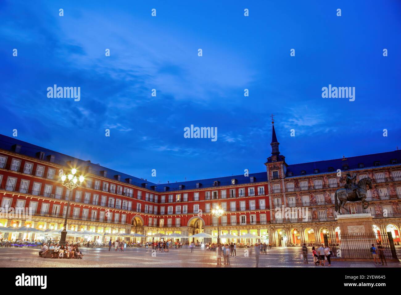 The lively Plaza Mayor in Madrid, Spain, illuminated at dusk with its ...
