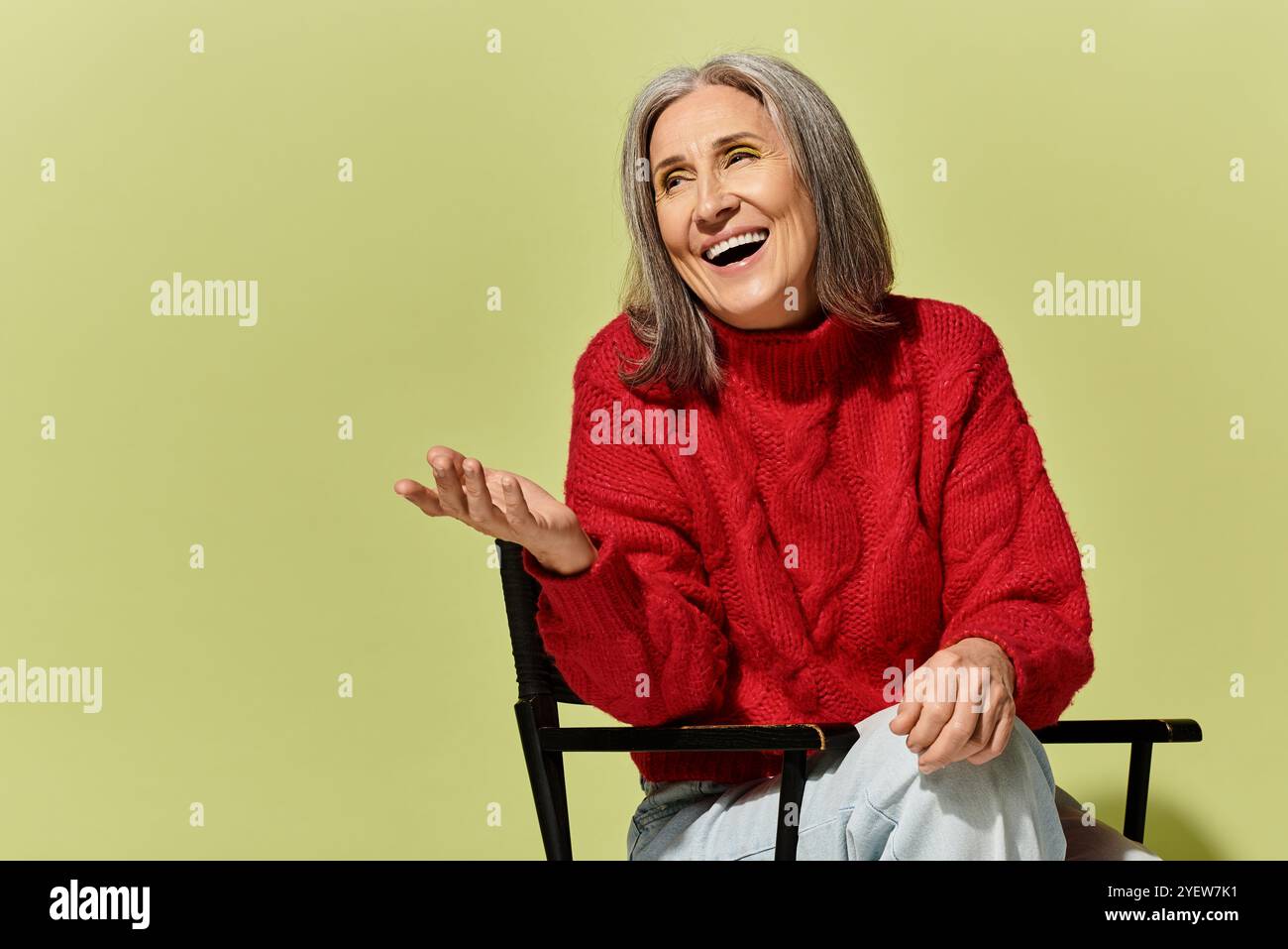 A cheerful woman with grey hair smiles radiantly while wearing a cozy ...