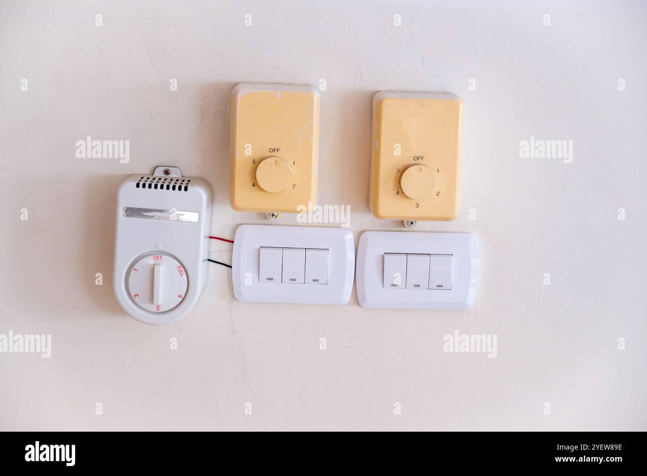 A close-up image of a wall-mounted control panel featuring switches and ...