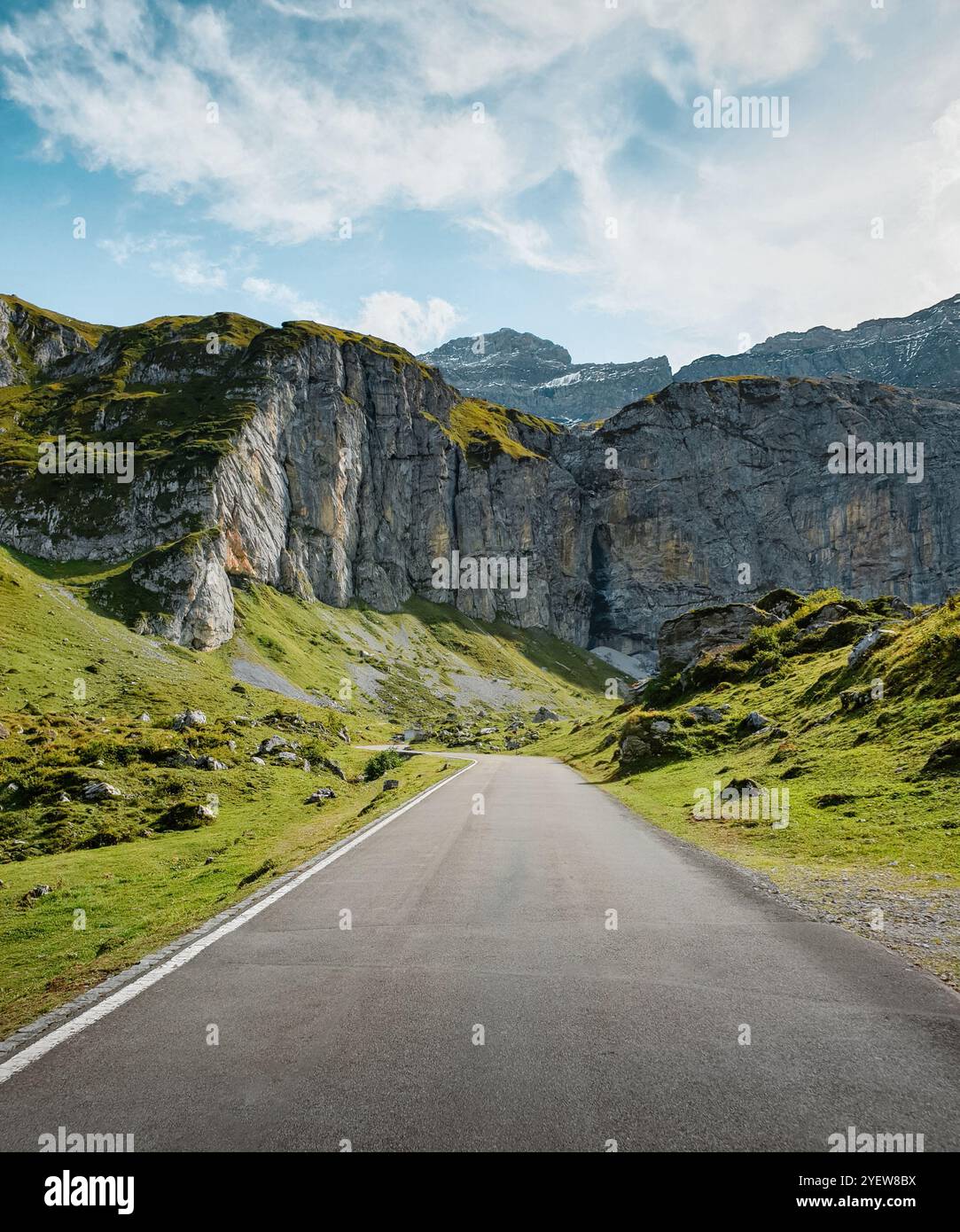 Road in Swiss alps. Empty road towards a cliff rock in Urner Boden ...
