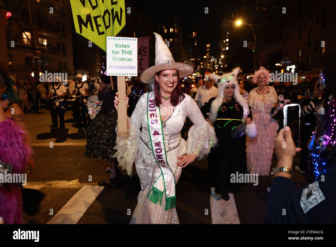 A group of women dressed as witches carrying a banner and signs march ...